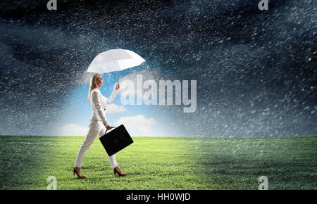 Elegant businesswoman hiding from rain under umbrella Stock Photo - Alamy