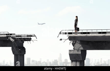 Businesswoman standing on edge of destructed bridge. Mixed media Stock ...