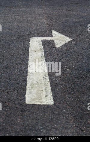 WHITE PAINTED ROAD TRAFFIC AHEAD DIRECTION SIGN ARROW ON ROAD SURFACE ...