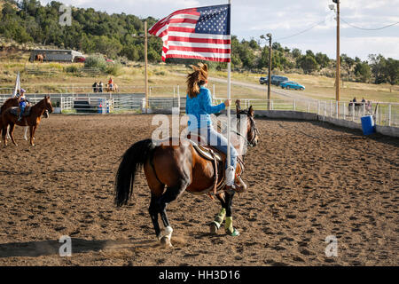 Cowgirl Carrying American Flag Riding Palomino Horse and Cowboy Stock ...