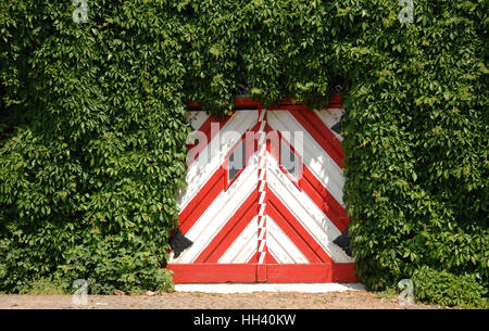 Two-winged wooden gate with red white stripes in a placid wall Stock ...