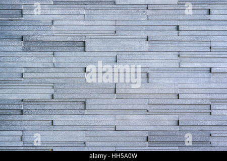 Gray stone tile wall surface with subtle linear patterns and geometric ...