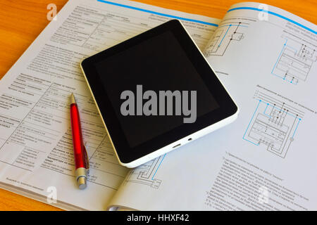 Tablet computer over engineering journal Stock Photo - Alamy