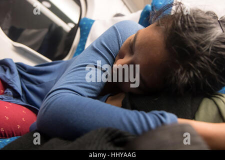 Person lying on train seat using a smartphone by the window with scenic ...