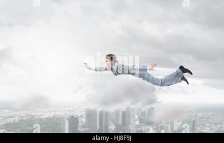 Young businessman superhero flying high in sky Stock Photo - Alamy