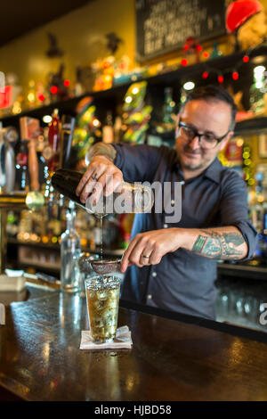 Barman pouring cocktail into glass Stock Photo - Alamy