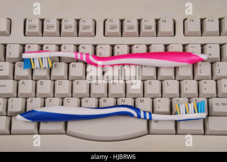 One computer keyboard and toothbrushes. Gray color Stock Photo - Alamy