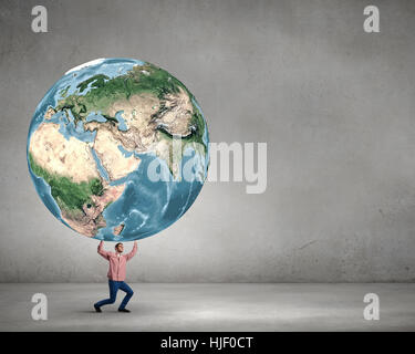 Young man lifting Earth planet above head. Elements of this image are ...