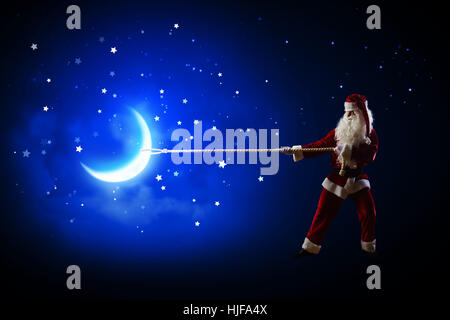 Image of Santa Claus pulling moon with rope Stock Photo - Alamy
