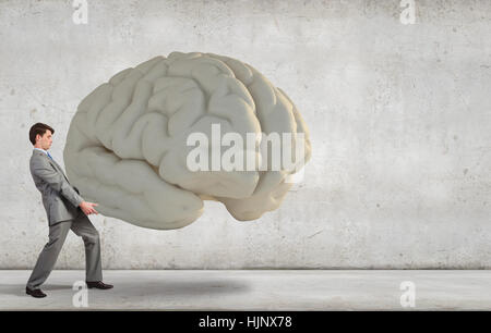 Businessman making effort to carry huge human brain Stock Photo - Alamy