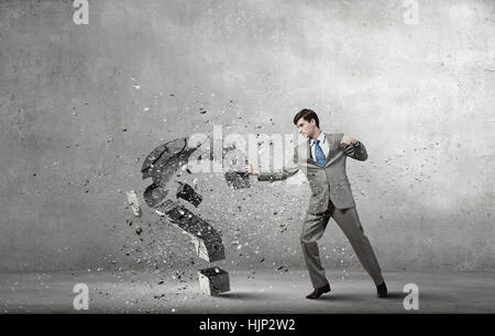 Businessman breaking stone question mark with karate kick Stock Photo ...