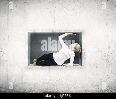Young businesswoman trapped in stone cube in wall Stock Photo - Alamy