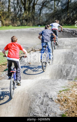 Three young boys cycling along a path in Thorndon Country Park in Stock ...