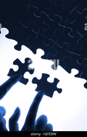 puzzle piece coming down into its place Stock Photo - Alamy