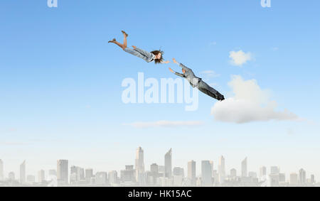 Two young business people flying in sky Stock Photo - Alamy