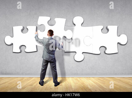 Rear view of businessman connecting white puzzle Stock Photo - Alamy