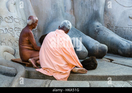 A Digambara-Monk without clothes and his student resting at the feet of ...
