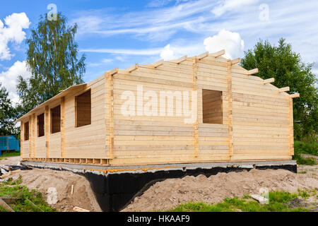 Construction of a wooden house on a sunny day in spring. New log house ...