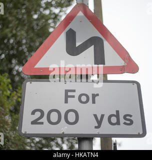 Bendy road warning in traffic Stock Photo - Alamy