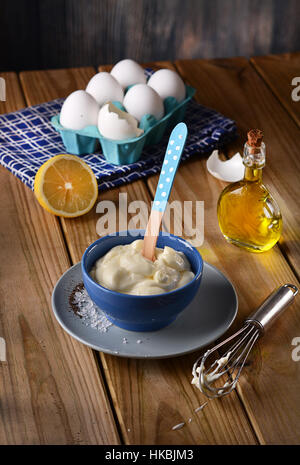 mayonnaise in blue bowl with ingredients around - traditional European ...