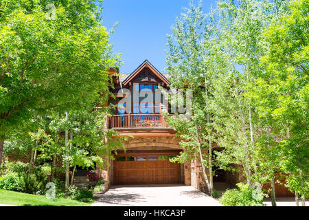 Wooden house with trees around it in sunny day Stock Photo - Alamy