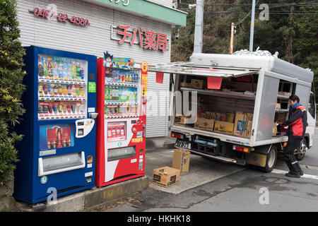Delivery man replenishing vending machines with drinks from his van ...