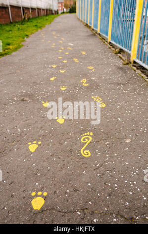 Painted yellow footprints on the sidewalk Stock Photo - Alamy