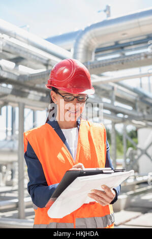 Female engineer writing in check list during repair works Stock Photo ...