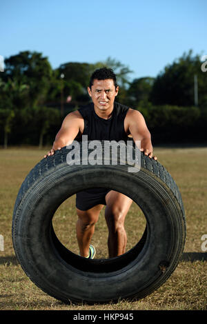 strongman flip big tire outdoor on stadium grass Stock Photo - Alamy