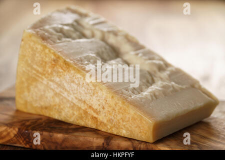 big chunk of italian parmesan cheese on wooden cutting board Stock ...