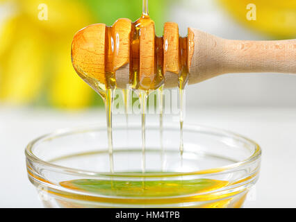 Golden honey dripping from dipper Stock Photo - Alamy