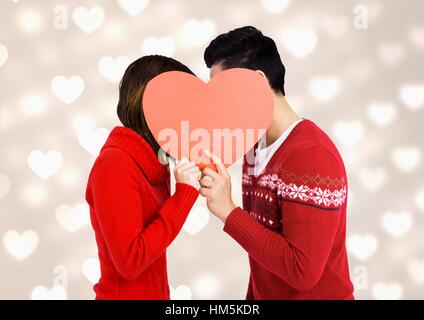 Romantic couple hiding their face behind heart Stock Photo - Alamy