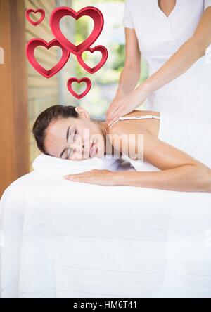 Masseur giving mid-back massage to female client using petrissage ...