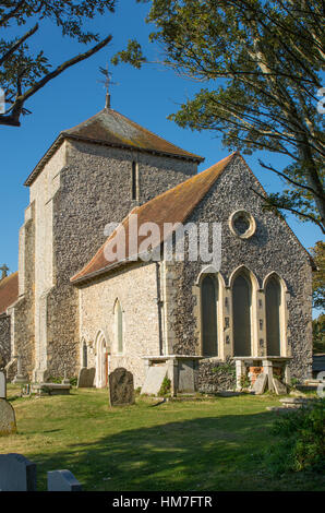 Saint Margarets Church, Rottingdean, East Sussex. A woman sits on a ...