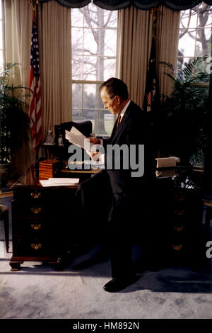 President George H.W. Bush at his desk in the Oval Office of the White ...