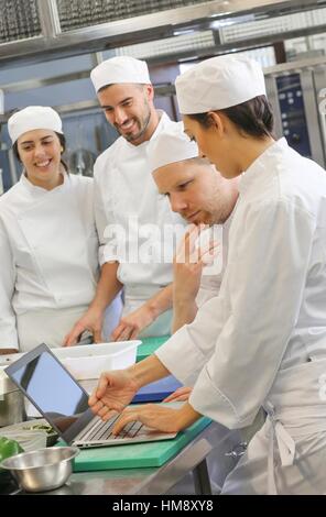 Chefs using computer in restaurant kitchen Stock Photo - Alamy