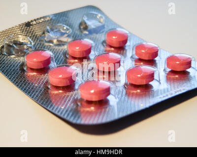 Stack of pink tablet pills of ibuprofen medicine for treatment migraine ...