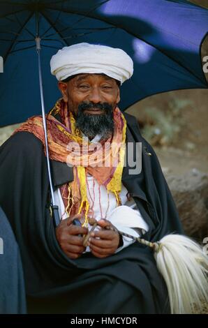 Coptic priest shading himself under an umbrella, Timkat festival ...