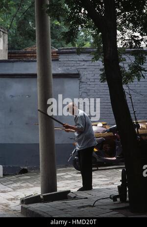 Man holding sticks, Beijing, China Stock Photo - Alamy