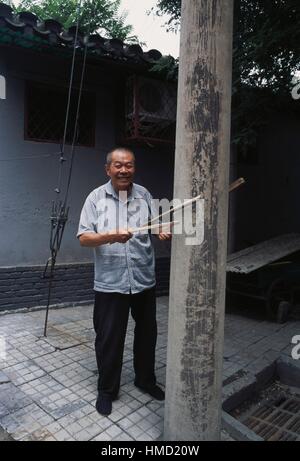 Man holding sticks, Beijing, China Stock Photo - Alamy