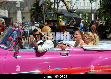 Tourists take a ride in a classic American car in Havana, Monday, Jan ...
