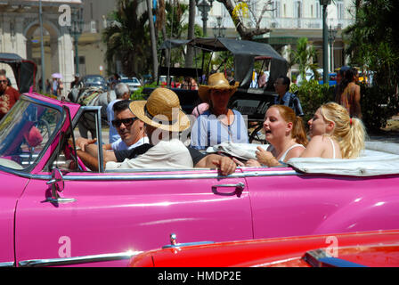 Tourists take a ride in a classic American car in Havana, Monday, Jan ...