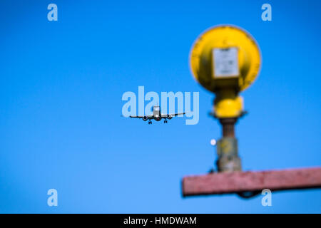 Jet airplane flying overhead close-up on a blue sky background Stock ...