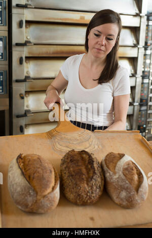 a professional chef prepares and cooks loafs of bread and baking ...