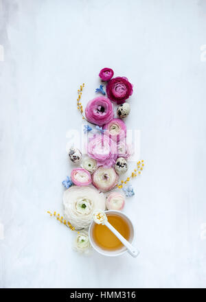 Painted Easter eggs with mimosa, pink and green spring flowers in ...