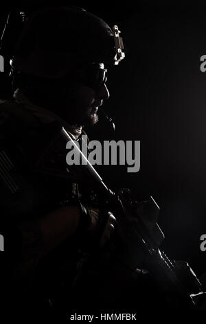 Backlit silhouette of special forces marine operators in military kayak ...