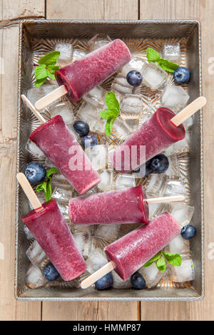 Blueberry ice cream popsicles top view on blue Stock Photo - Alamy
