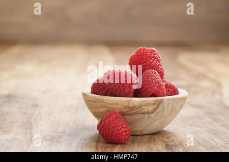 wood bowl full of ripe raspberries on old wooden table Stock Photo - Alamy