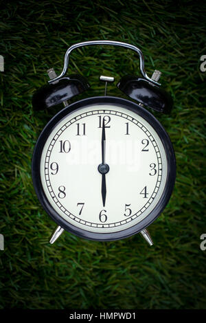 times retro clock lay on green grass nature face timed at 6 o'clock ...