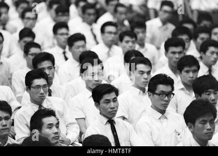 Young men at a Soka Gakkai meeting, chanting. This photograph was taken ...